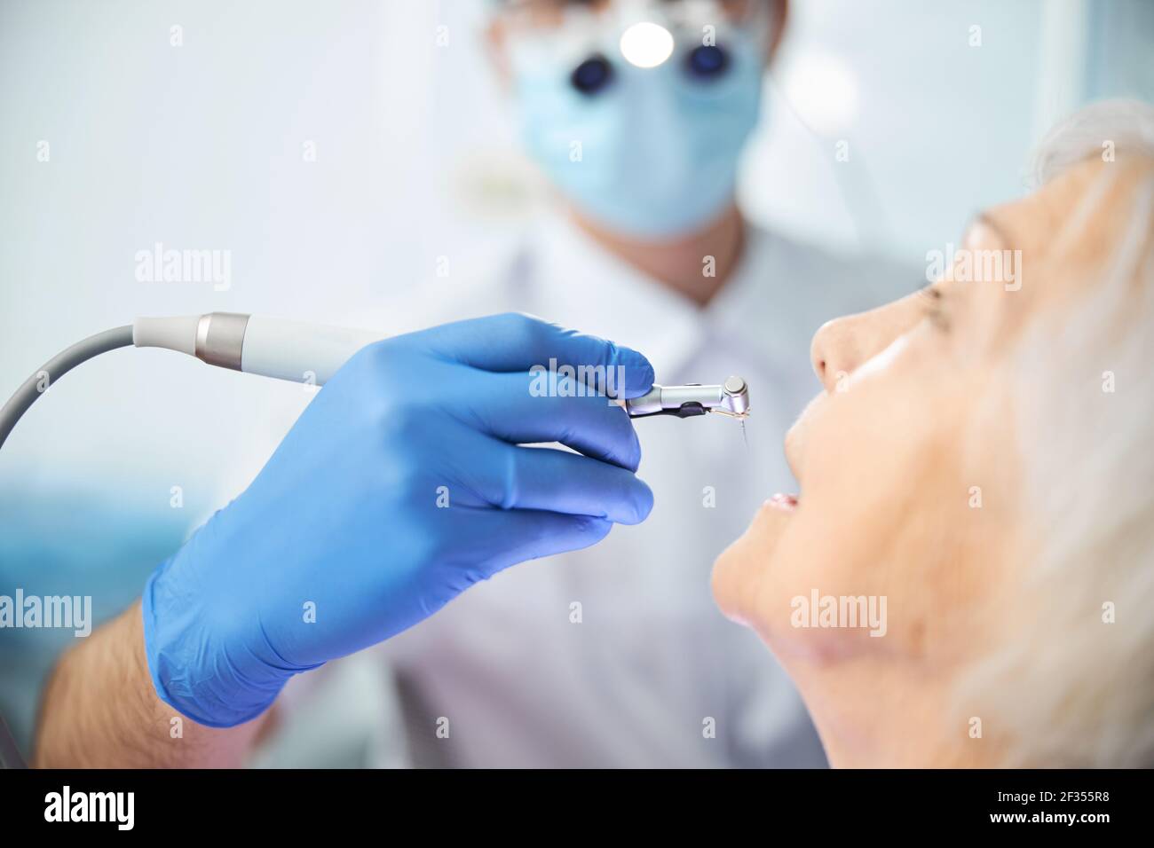 Hand lowering dental handpiece with bur to pensioner teeth Stock Photo ...