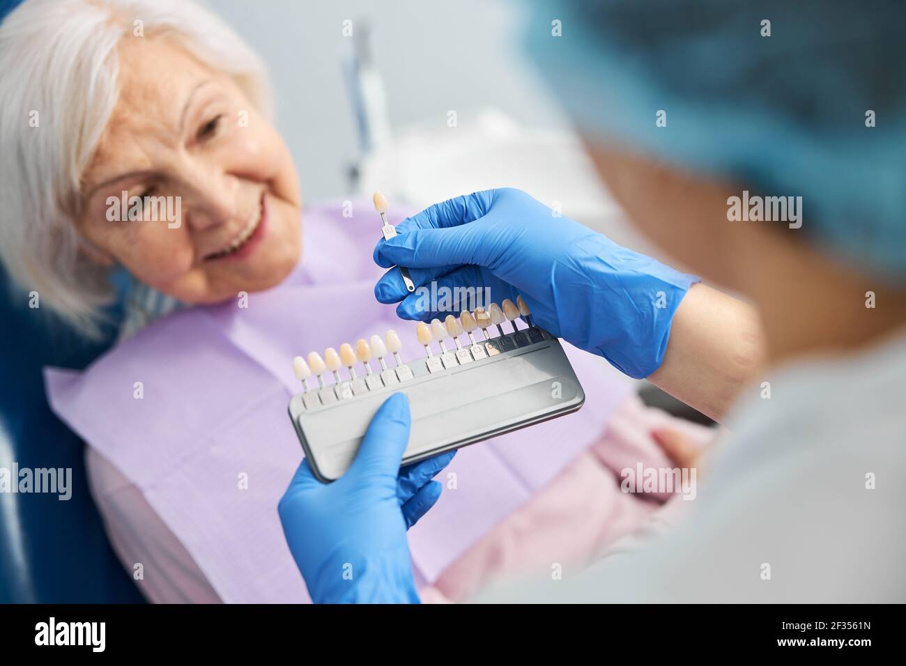 Orthodontist pulling out one tooth model from shade guide rack Stock ...