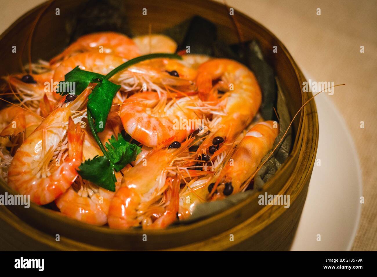 a steam basket with with steamed river prawns and garnished with ...
