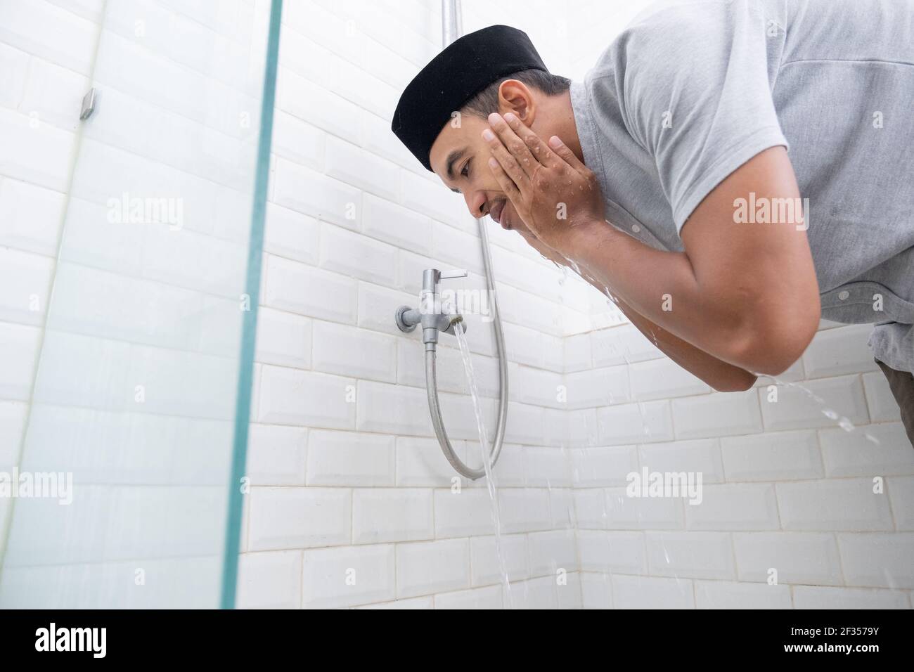 Young Muslim man perform ablution wudhu before prayer at home Stock ...