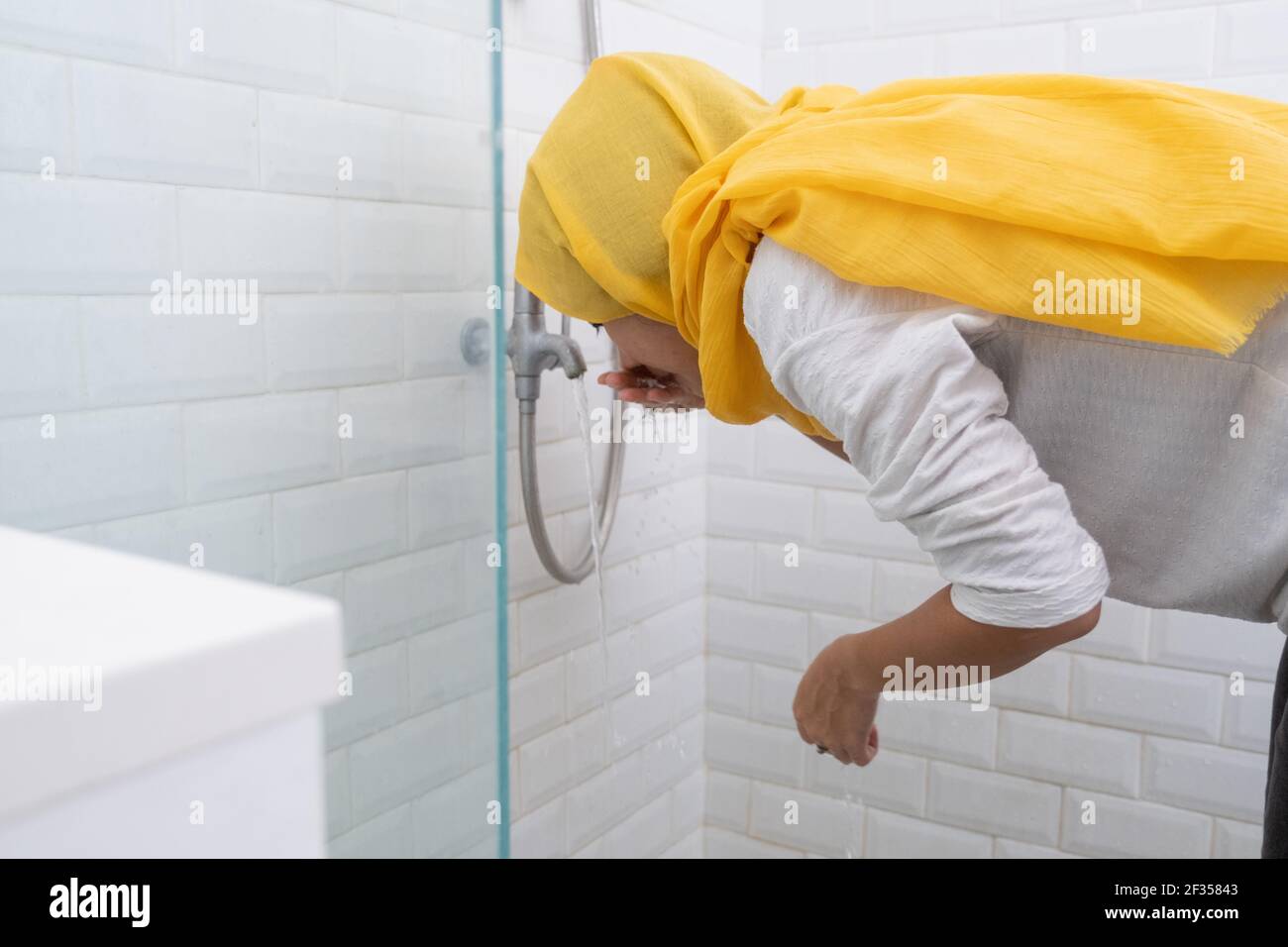 Young Muslim woman perform ablution wudhu before prayer at home Stock ...