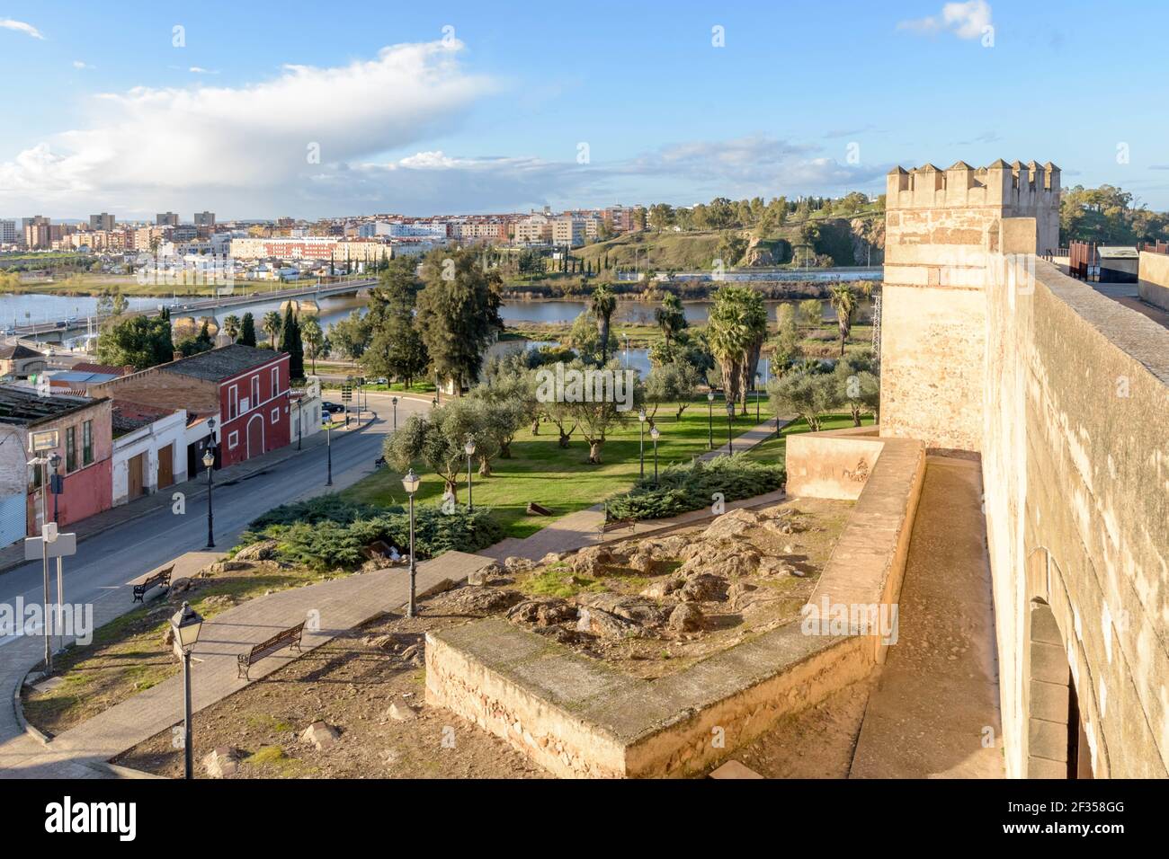 A landscape of Badajoz covered in greenery and buildings under a blue ...
