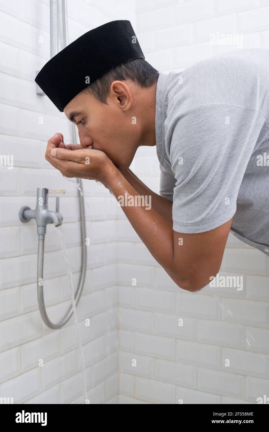 Young Muslim man perform ablution wudhu before prayer at home Stock ...