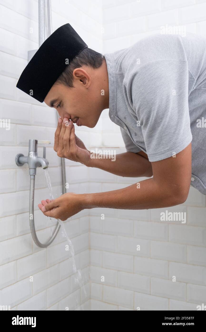 Young Muslim man perform ablution wudhu before prayer at home Stock ...