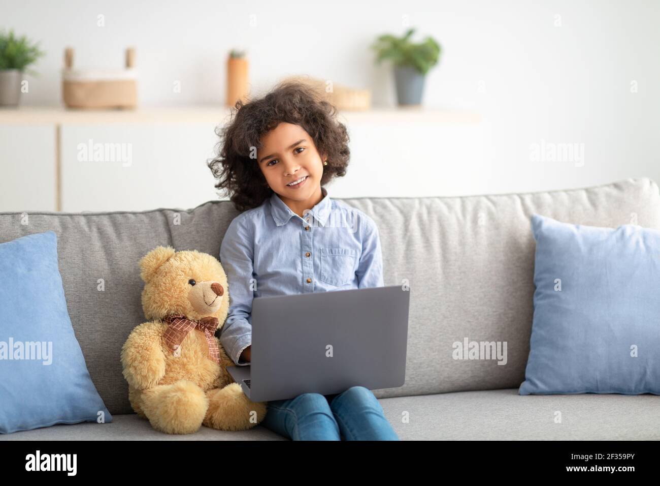 Girl sitting on the couch and using her laptop computer Stock Photo - Alamy