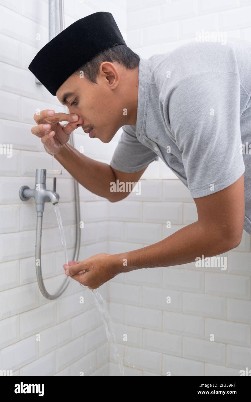 Young Muslim man perform ablution wudhu before prayer at home Stock ...