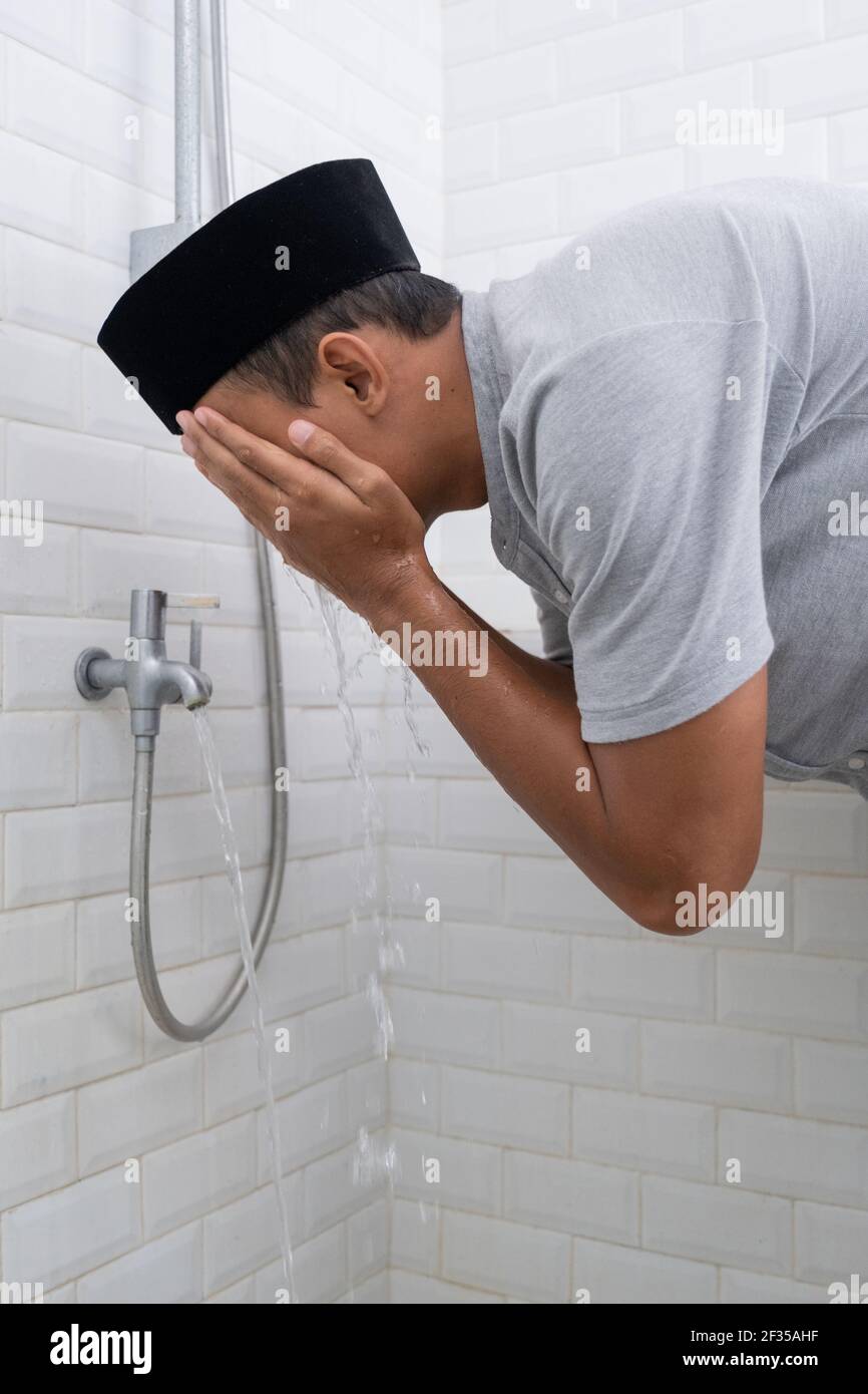 Young Muslim man perform ablution wudhu before prayer at home Stock ...