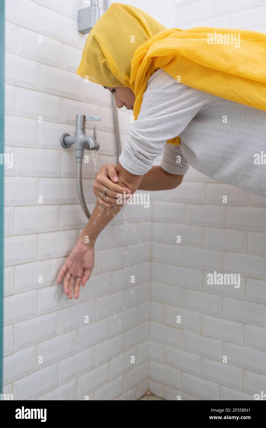 Young Muslim woman perform ablution wudhu before prayer at home Stock ...
