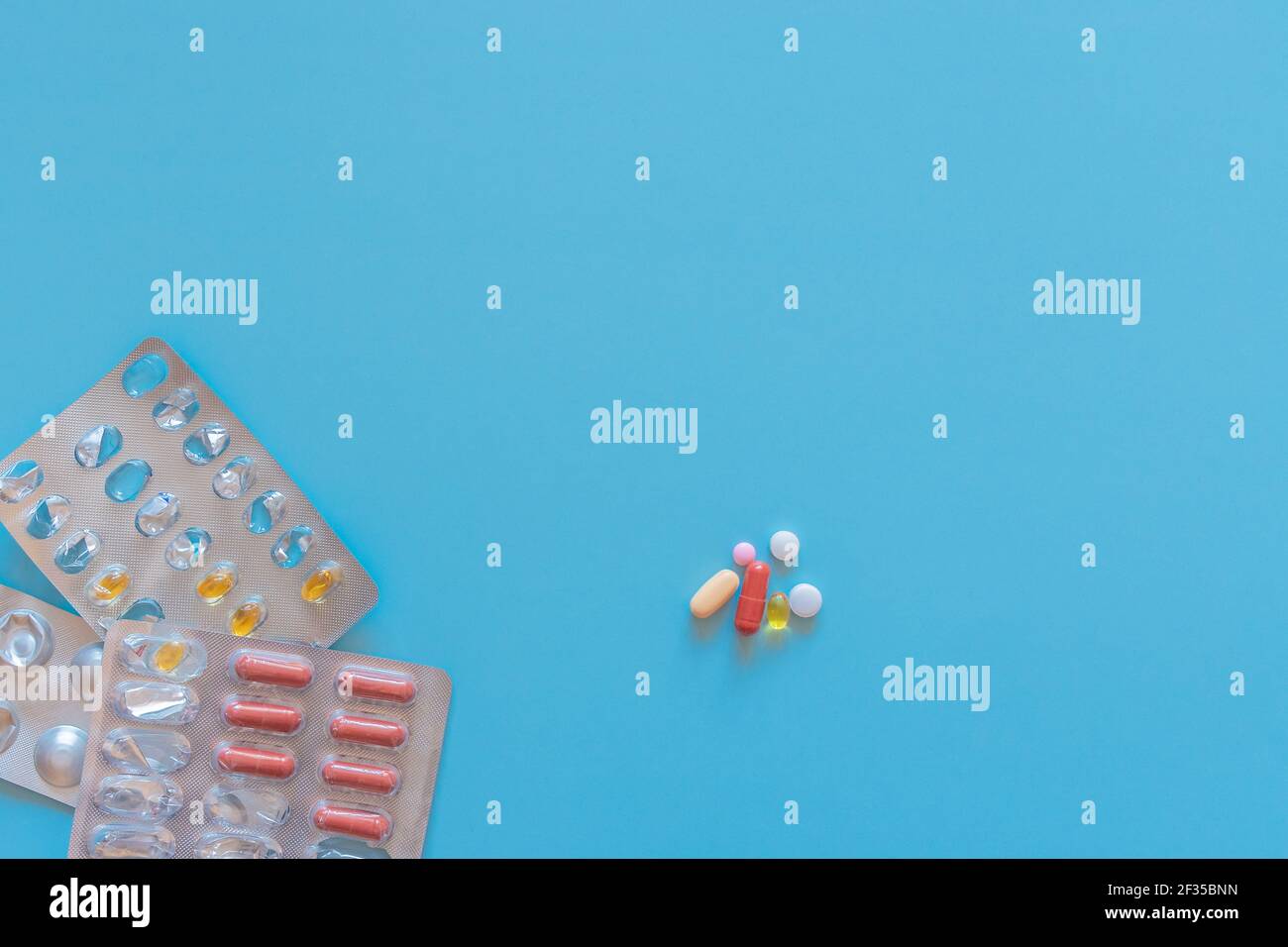 Colorful medication on turquoise surface and in blister pack ...