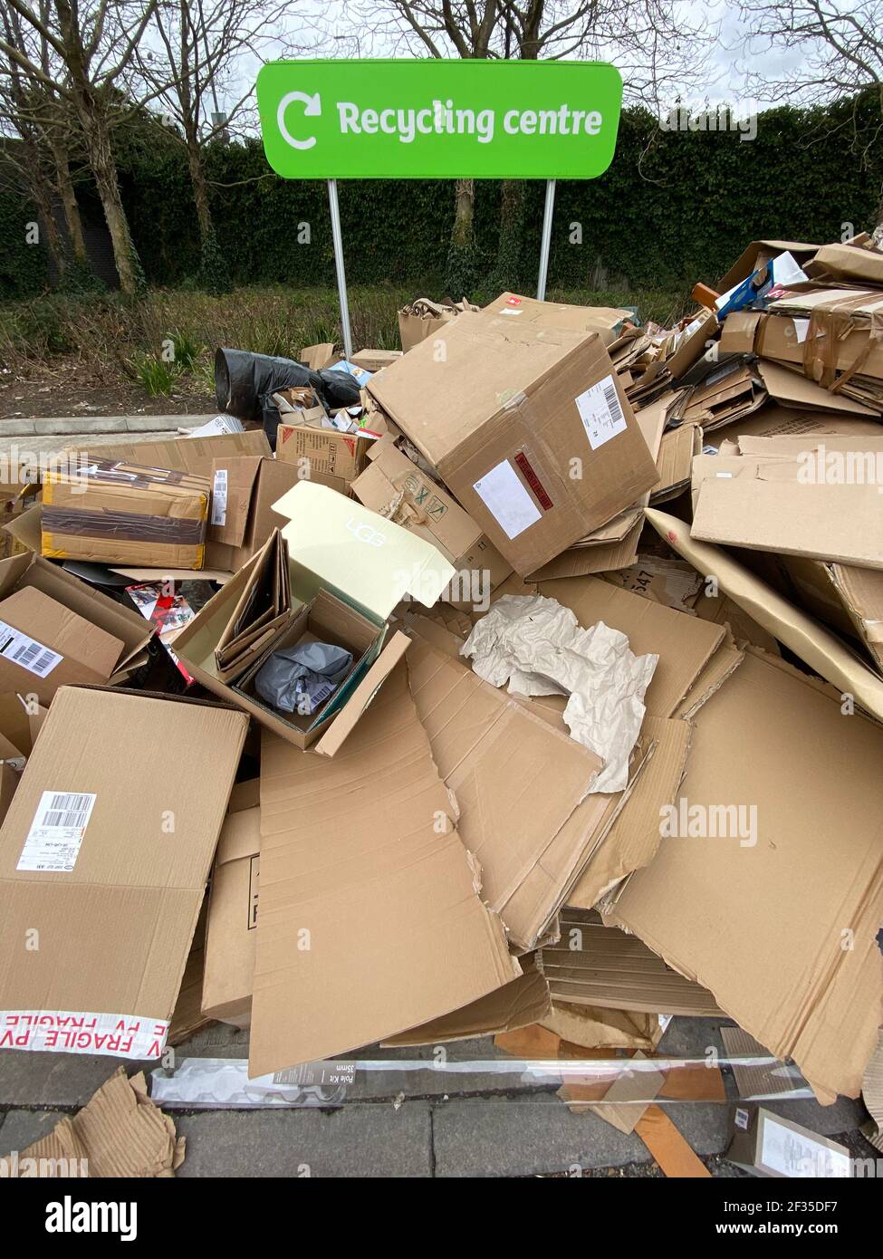 Cardboard boxes in front of a Recycling centre sign in a supermarket ...