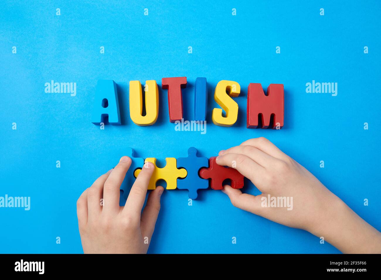 Autistic kid hands holding puzzle jigsaw and word autism, mental health ...