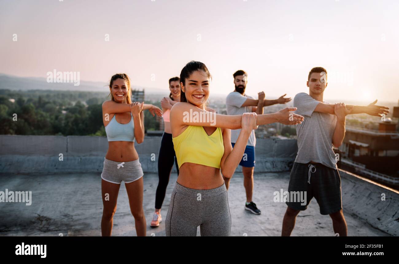 Group of cheerful fit fitness team exercising together outdoor Stock ...