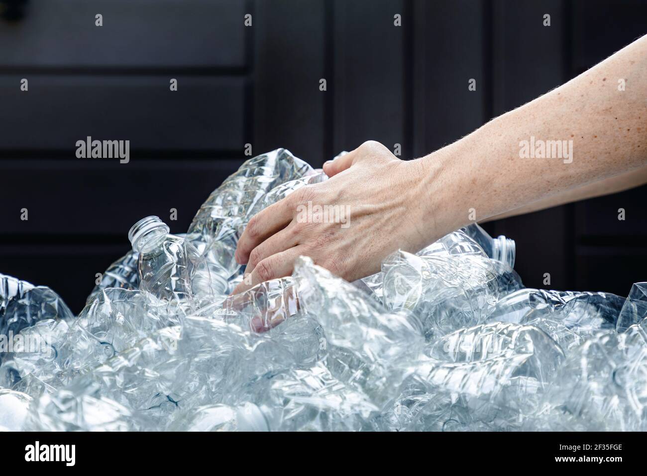 Femals hands grabbing plastic bottles to collect and trash them Stock ...