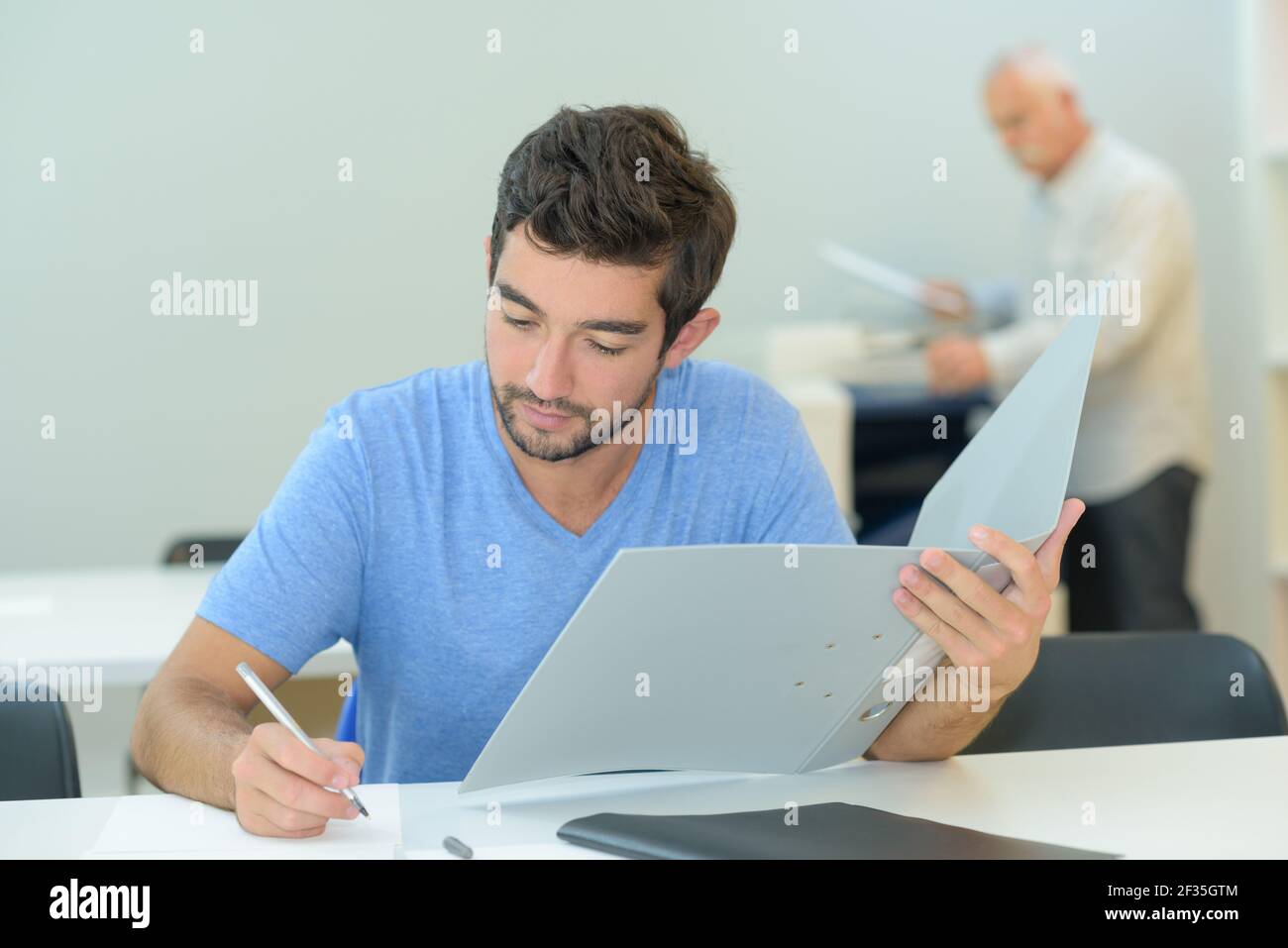 student with books writing school test Stock Photo - Alamy