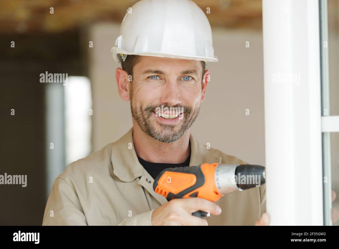 smiling man is fixing a window Stock Photo - Alamy