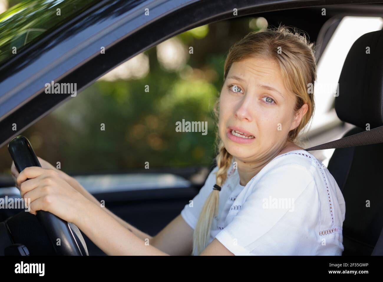 worried beautiful young blond woman driving a car Stock Photo - Alamy