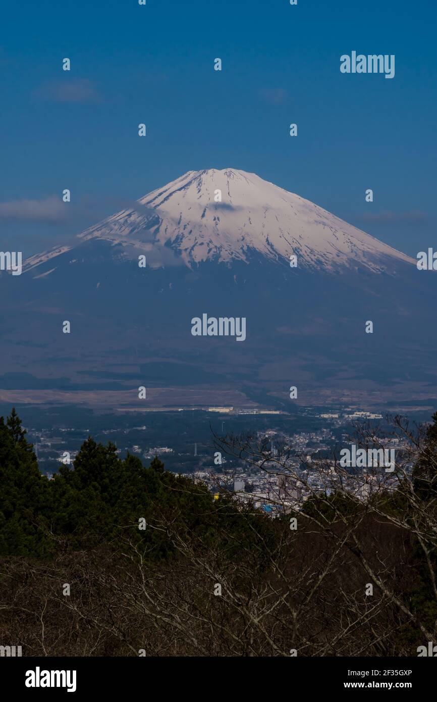 A bird's-eye vertical view of snow-capped Mount Fuji through clouds and ...