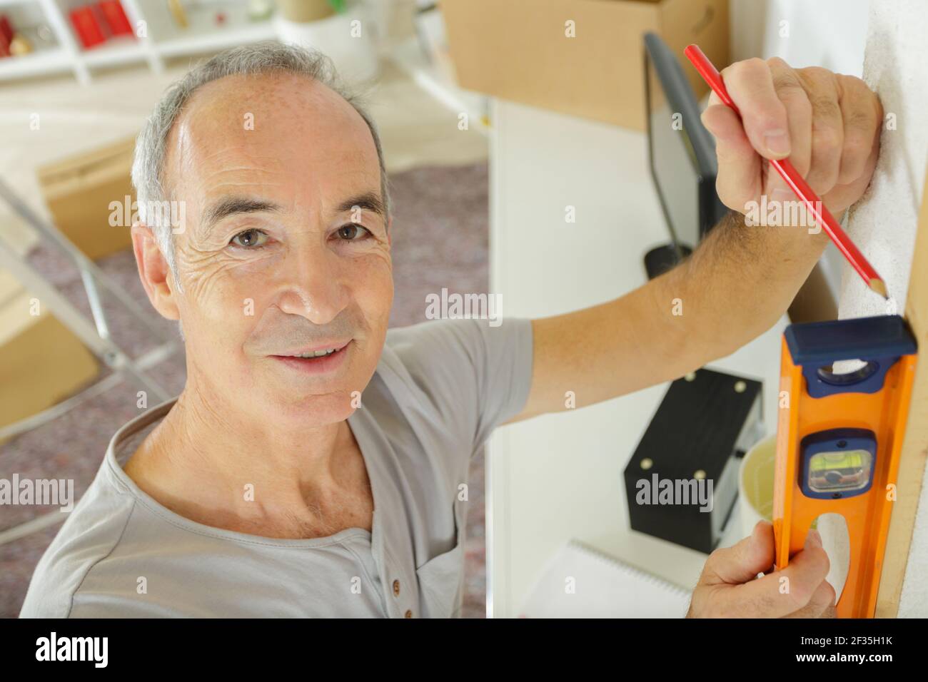 Senior man using level hi-res stock photography and images - Alamy