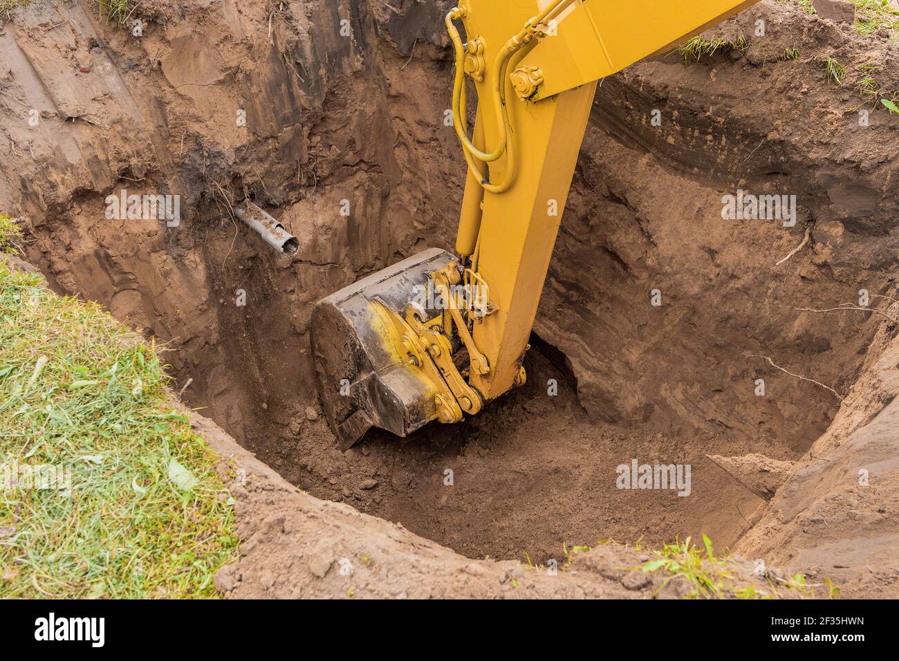 Hydraulic excavator piston digs deep pit in industrial area on ...