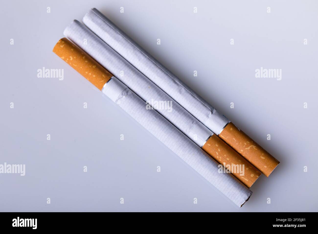 Three cigarettes in a row, on a white background Stock Photo - Alamy
