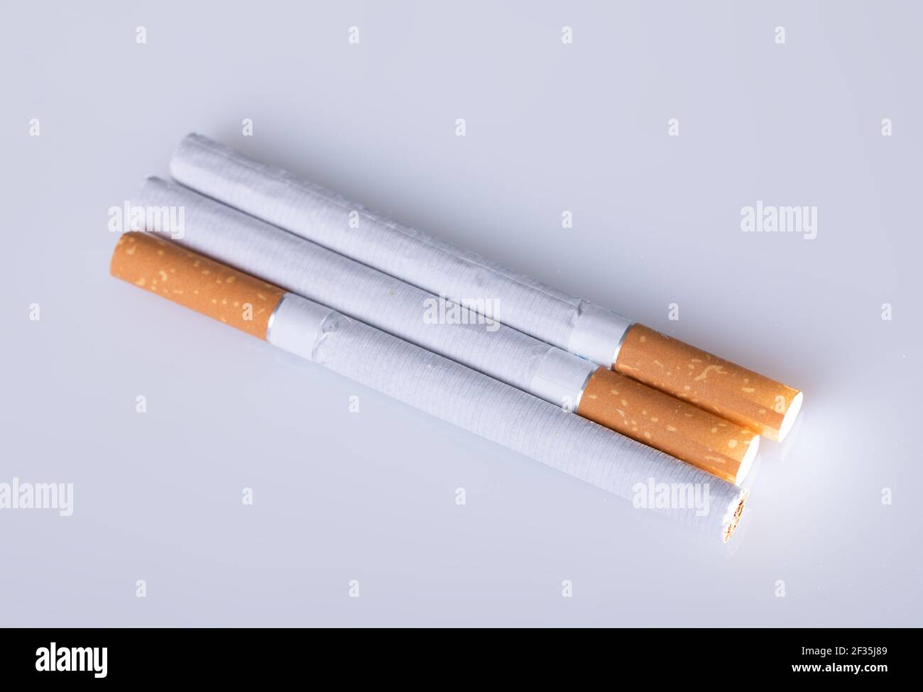 Three cigarettes in a row, on a white background Stock Photo - Alamy