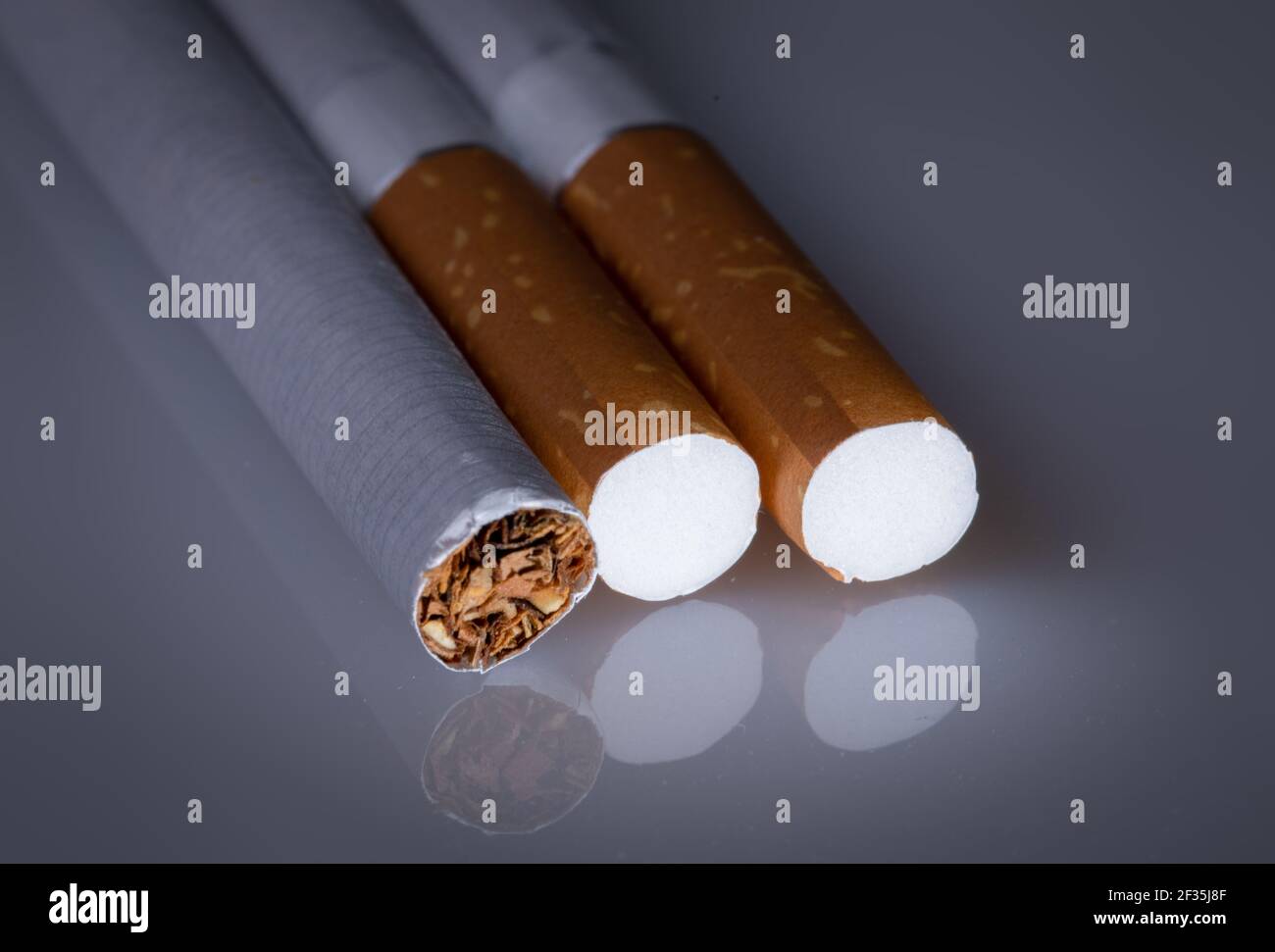 Three cigarettes in a row, on a white background Stock Photo - Alamy