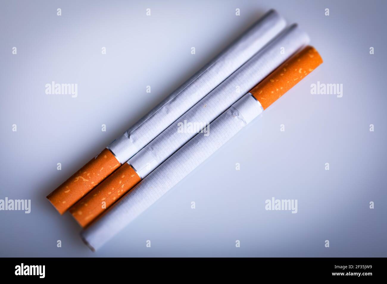 Three cigarettes in a row, on a white background Stock Photo - Alamy