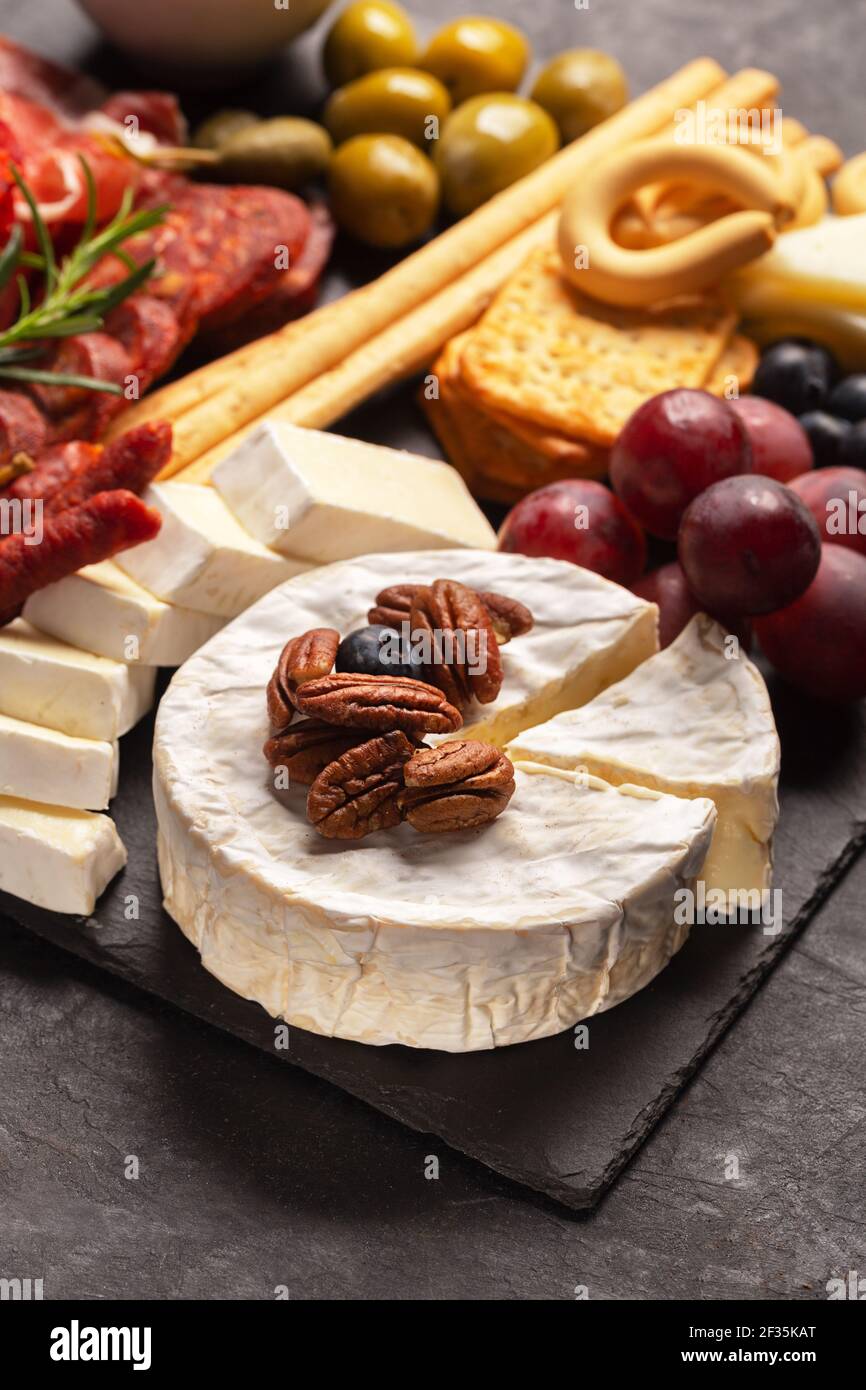 Charcuterie board with Camembert, fuet, nuts cheese and berries on a ...