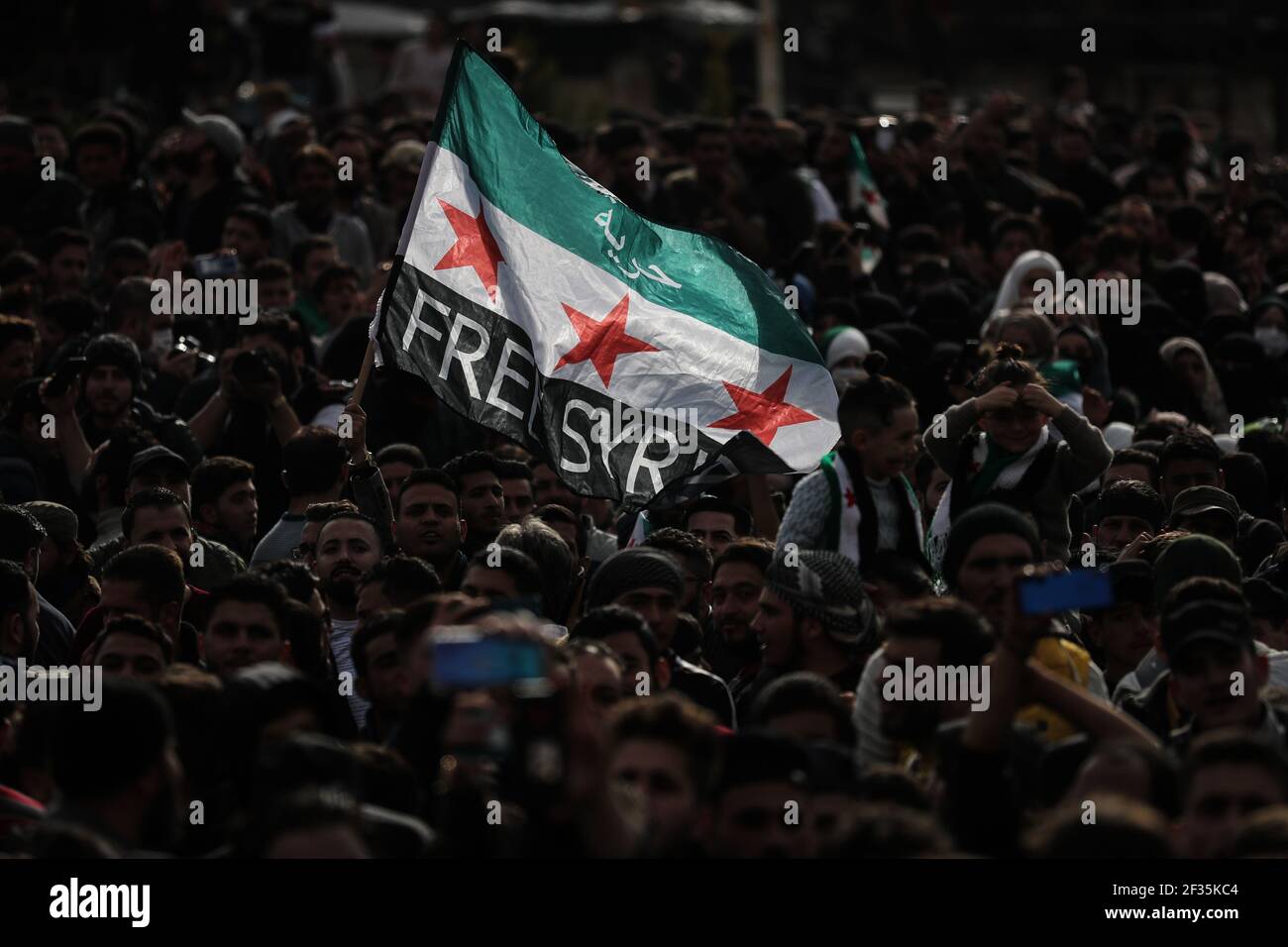 Idlib City, Syria. 15th Mar, 2021. People wave a flag of the Syrian ...