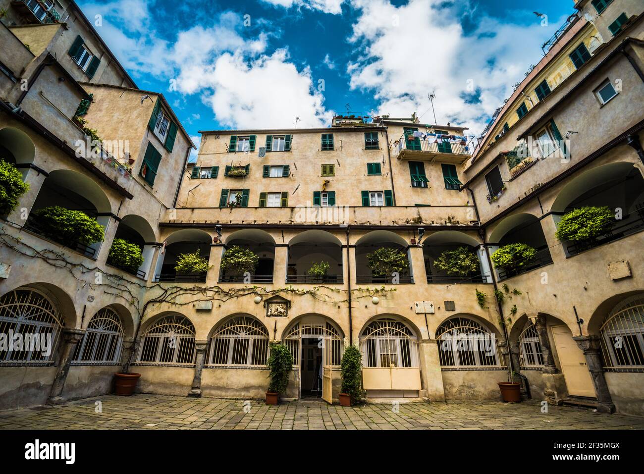 Old empty yard inside residential block. Gallery around with arches ...