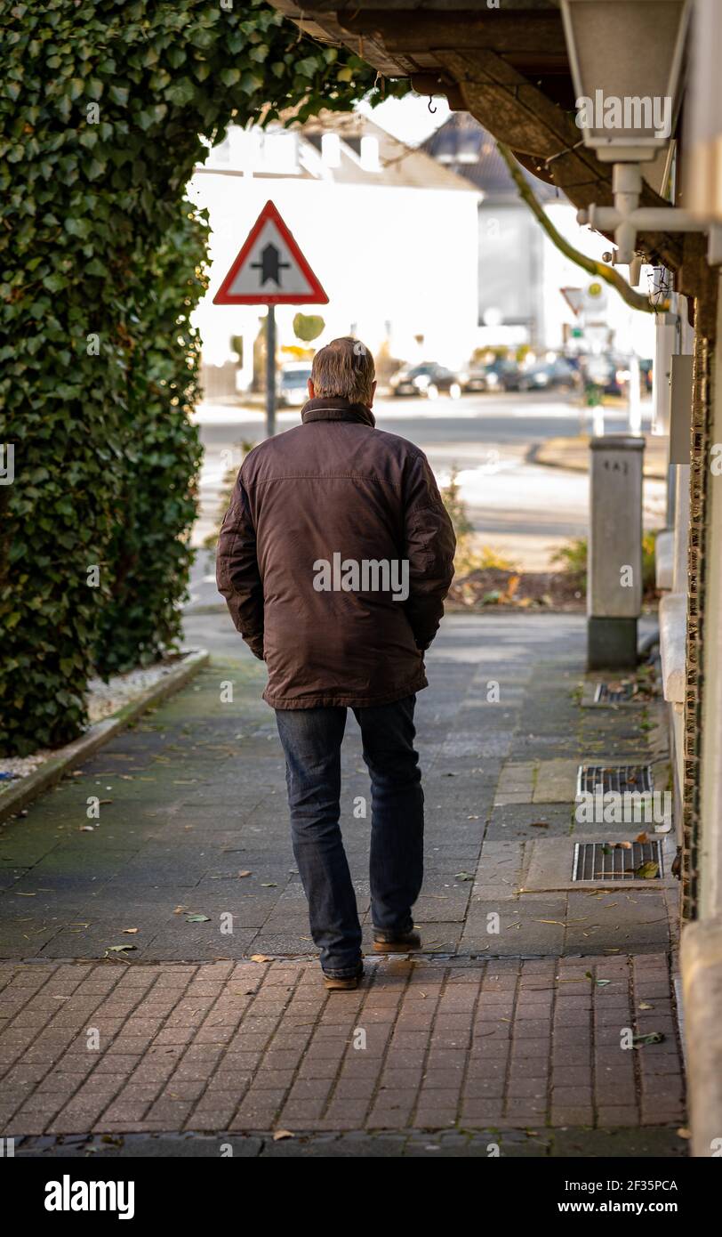 A vertical shot of an old man walking down the street Stock Photo - Alamy