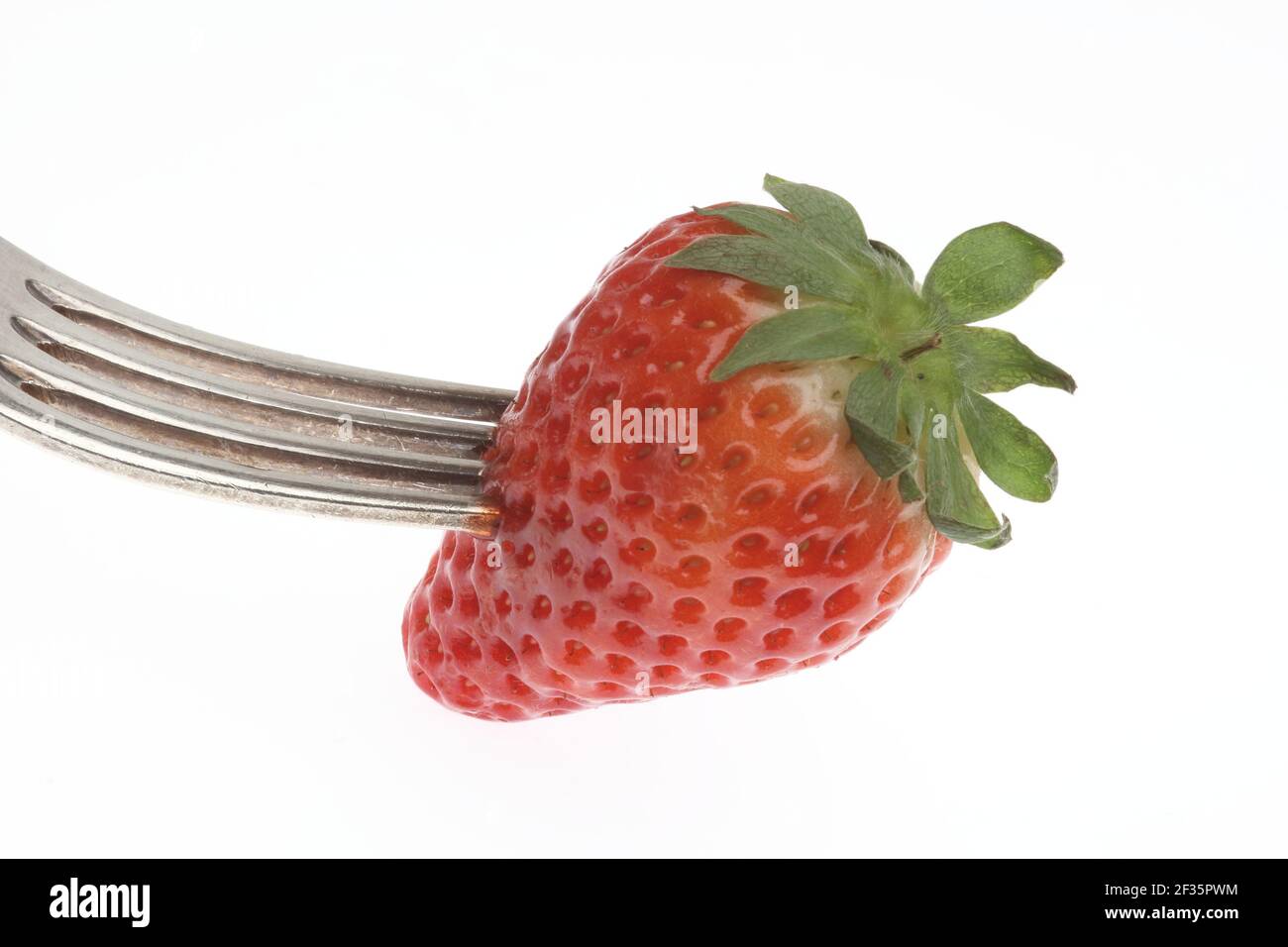 A strawberry on a fork isolated on white background Stock Photo - Alamy