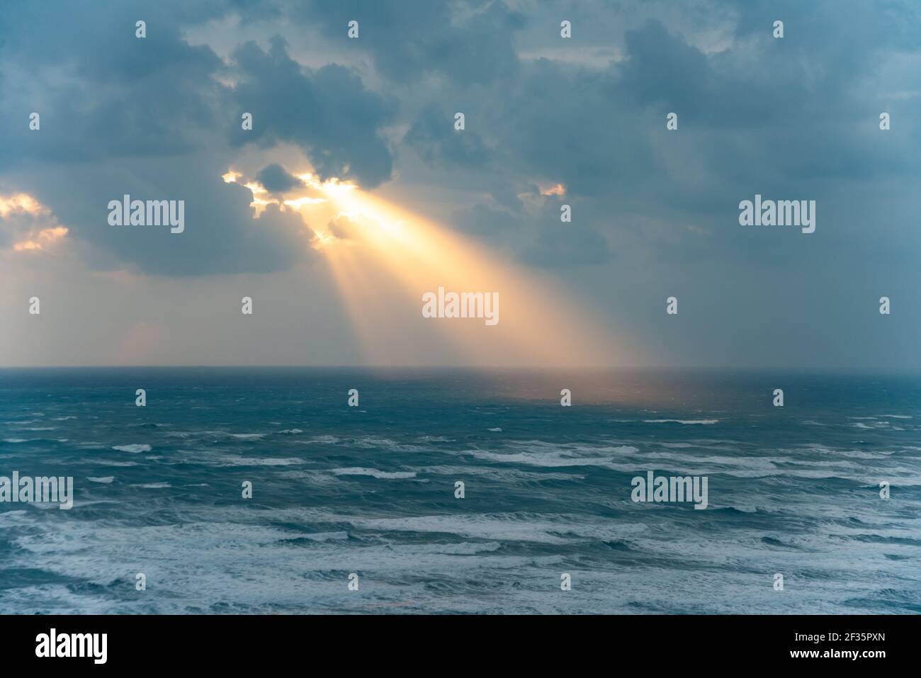 golden rays of the sun breaking through the storm clouds Stock Photo ...