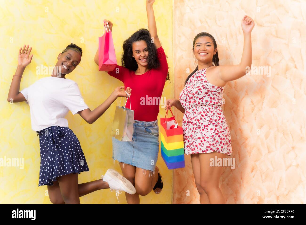 Three young smiling hipster women in summer clothes . Multiracial ...