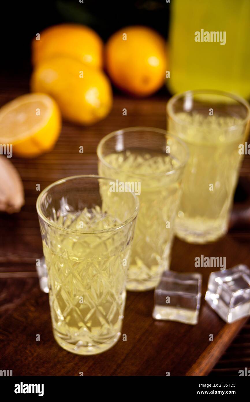 Italian drink lemon liqueur limoncello in glasses on the wooden table ...
