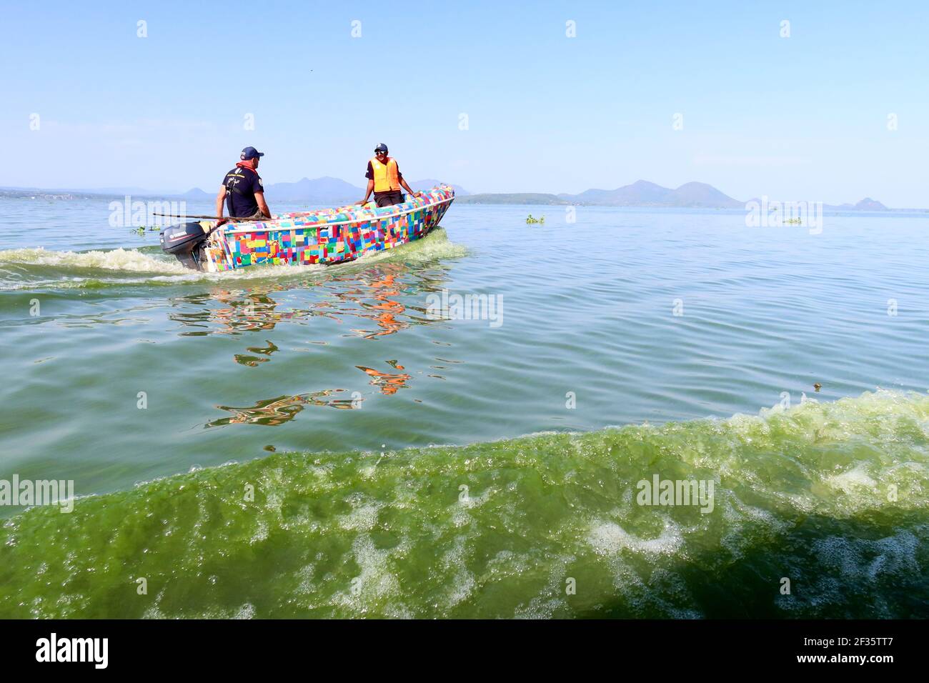 A boat going through an area of Lake Victoria affected by alga bloom ...