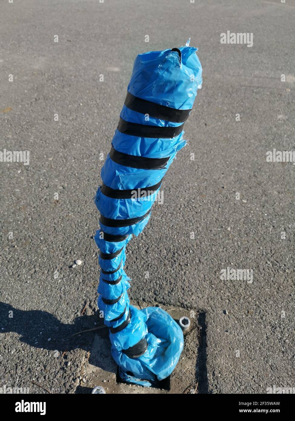 A stump of a damaged street lamp. secured with foil and tape. this ...