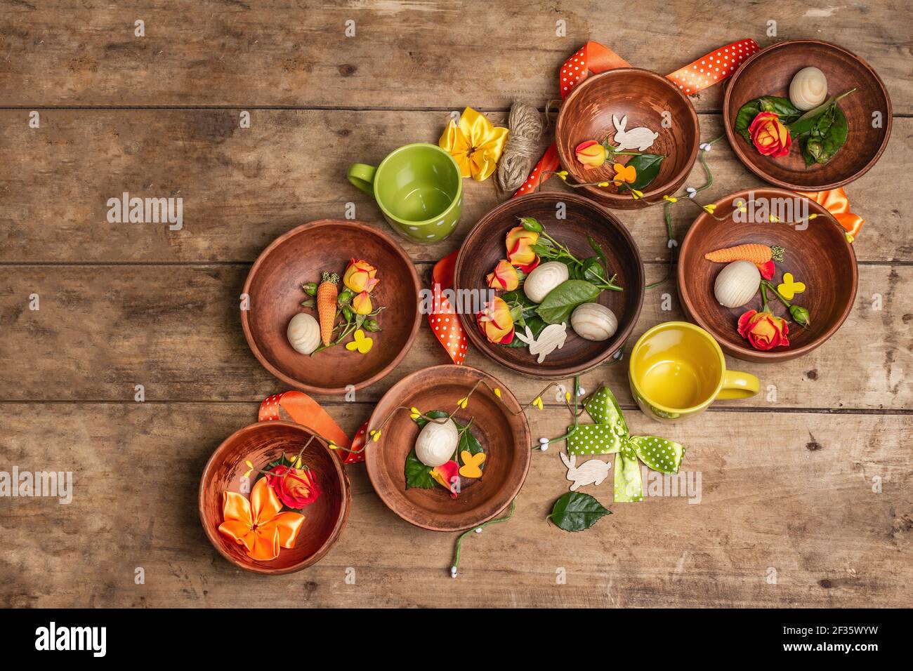 Easter ceramic bowls with eggs, bunnies, and fresh roses on a vintage ...