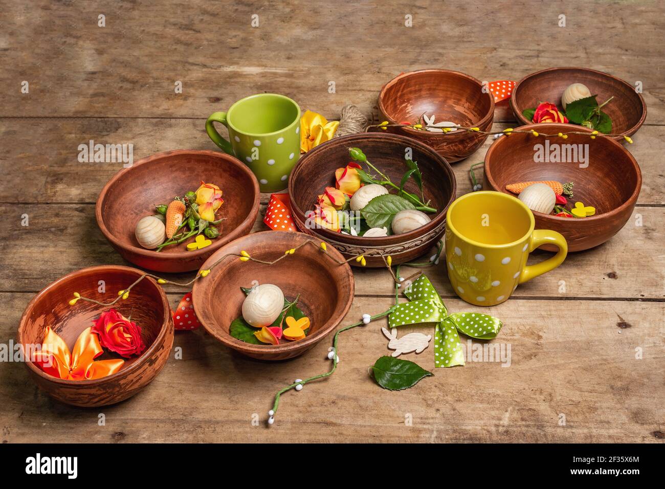 Easter ceramic bowls with eggs, bunnies, and fresh roses on a vintage ...