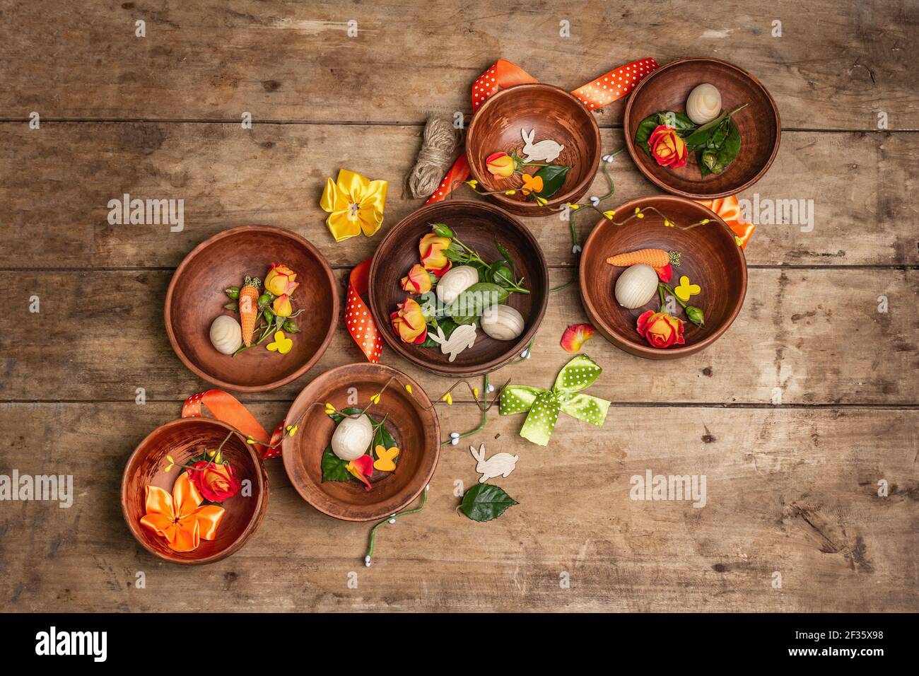 Easter ceramic bowls with eggs, bunnies, and fresh roses on a vintage ...