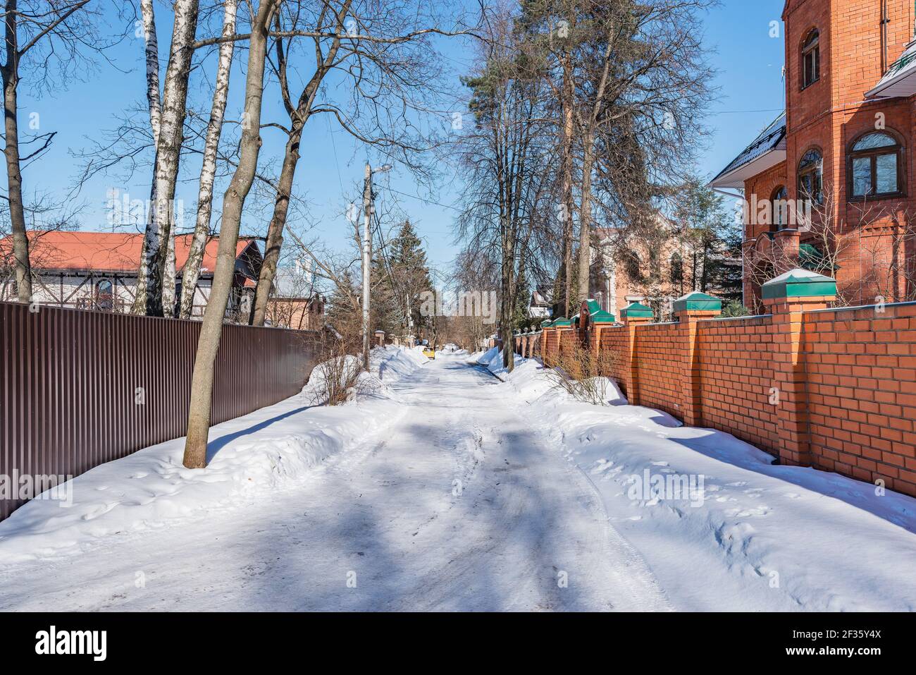 Long empty winter village street at sunny day Stock Photo - Alamy