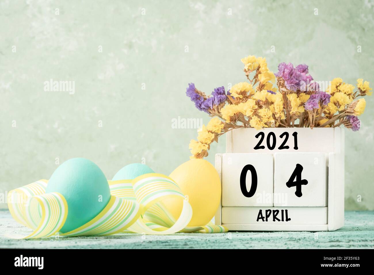 easter template with colorful eggs and cube calendar over green with ...