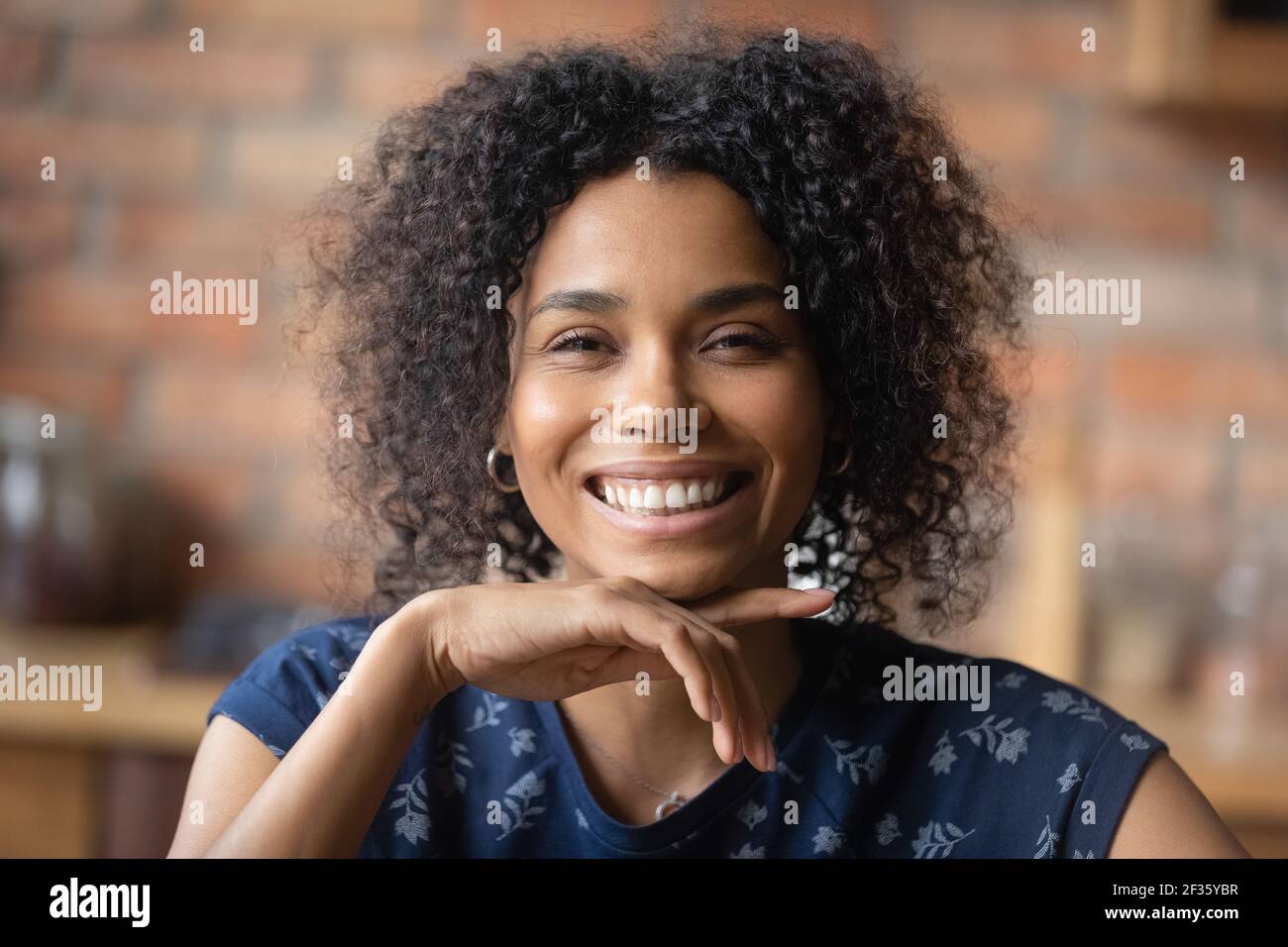 Laughing millennial black woman looking at camera flirtatiously ...