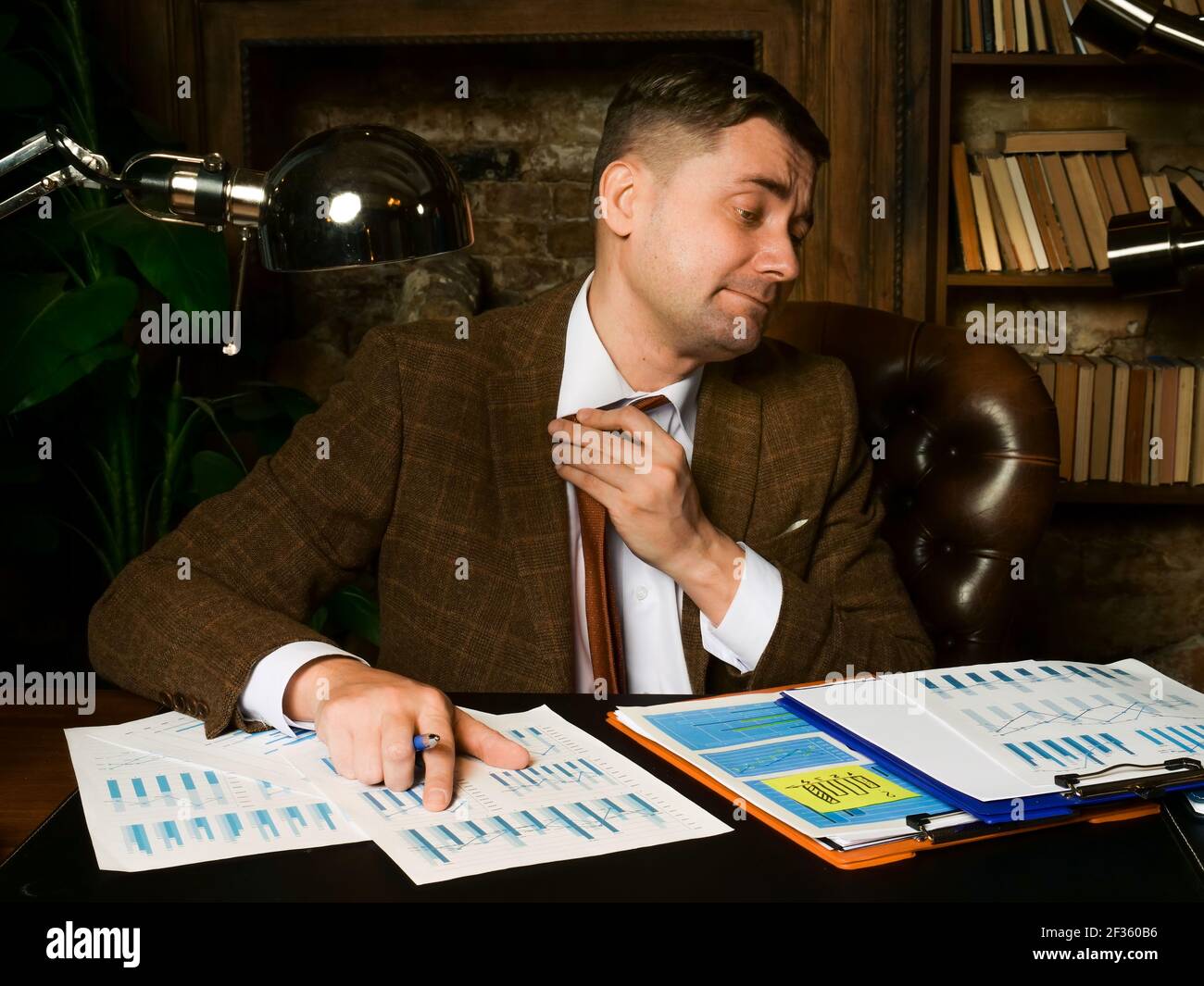 A sick, tired man loosens his tie late at work Stock Photo - Alamy