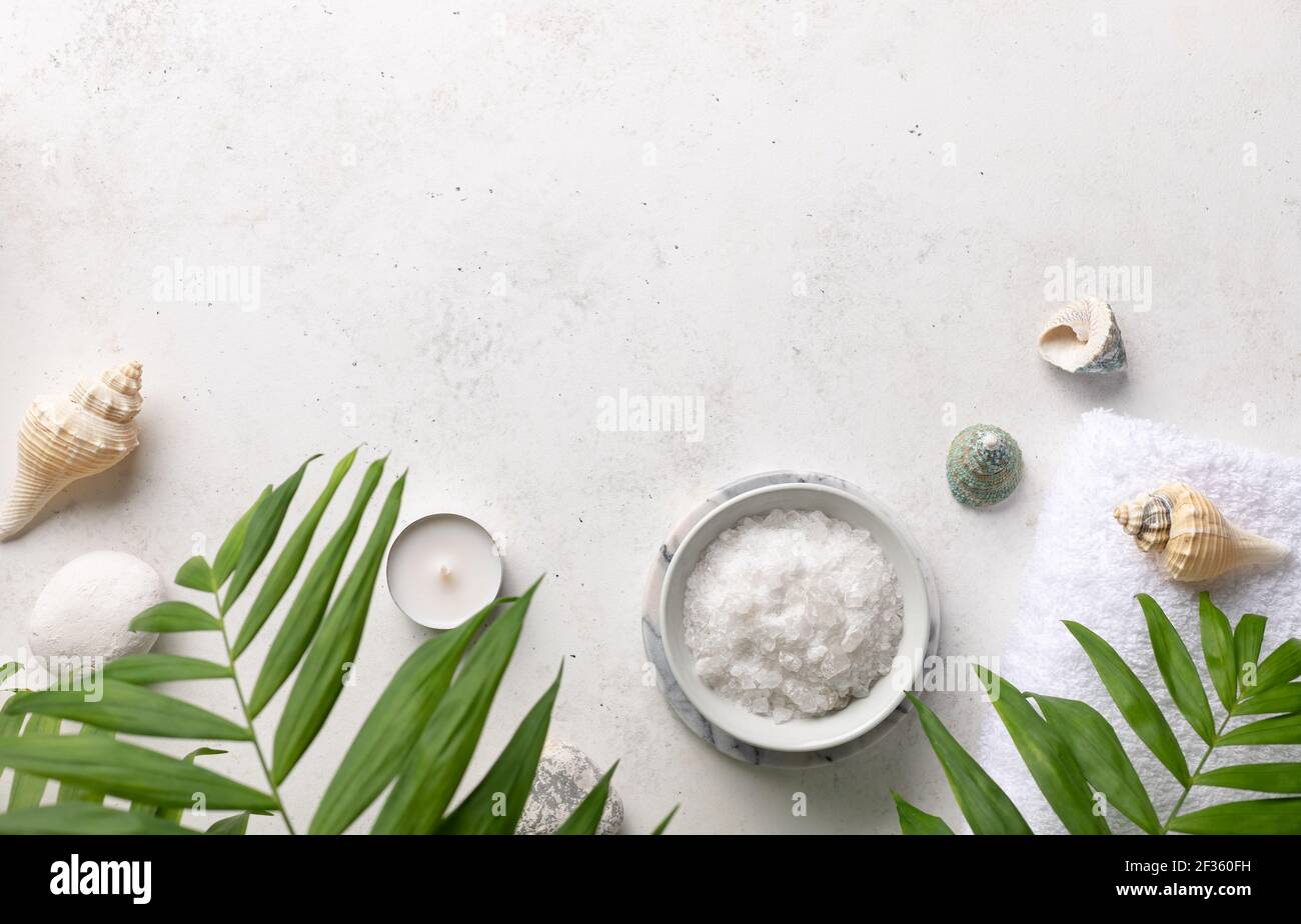 spa border with natural sea salt in a bowl, candles, shells and green ...