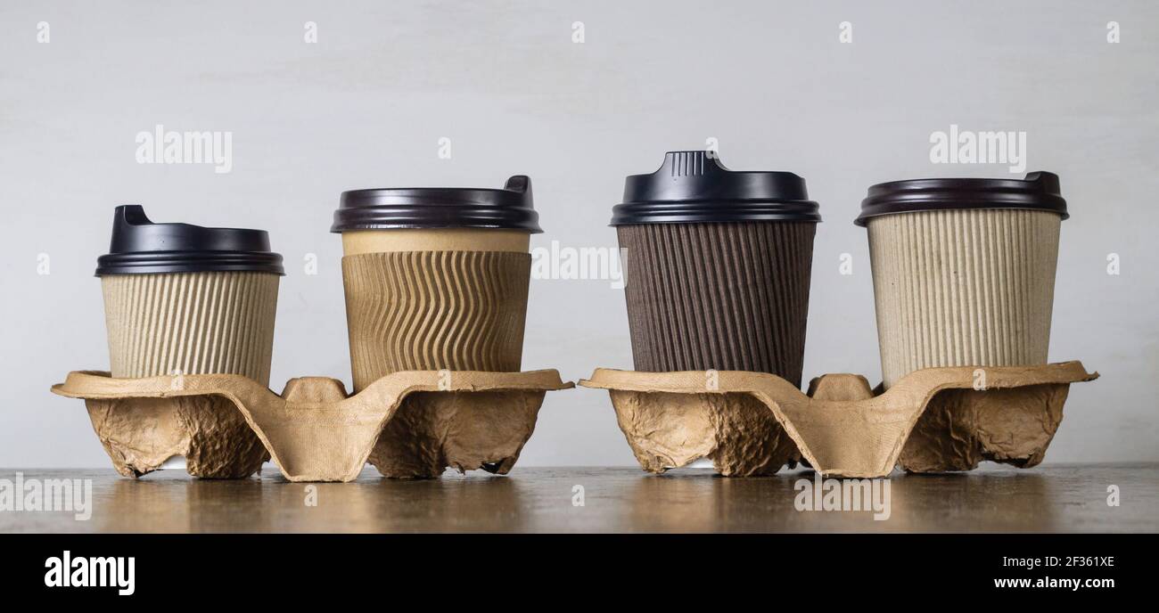 Four disposable paper coffee cups with lids in a cardboard holder ...