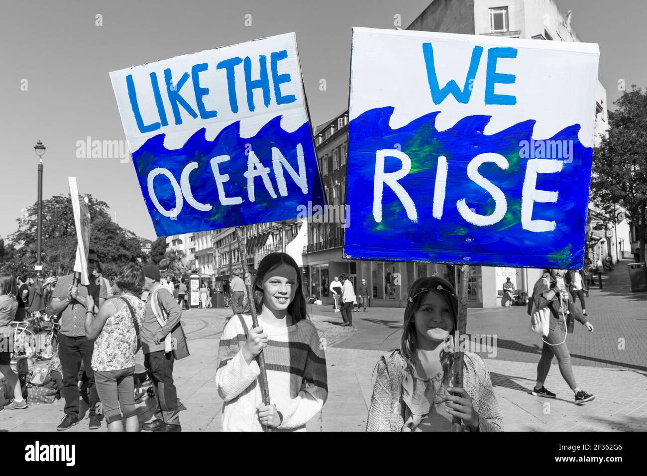 Girls holding placards - Like the ocean, we rise during climate change ...