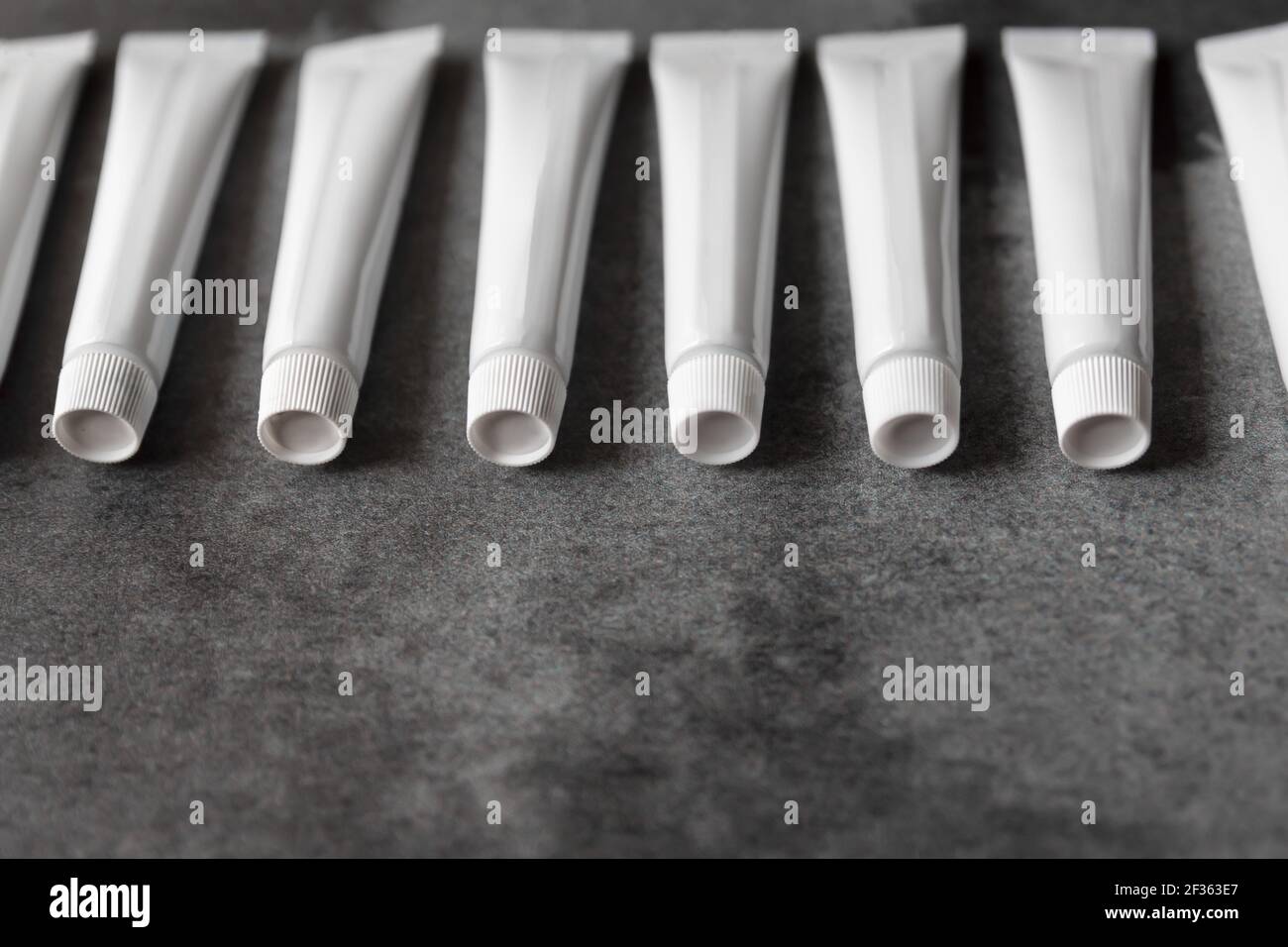 Container of white tubes on dark background with copy space, concept ...
