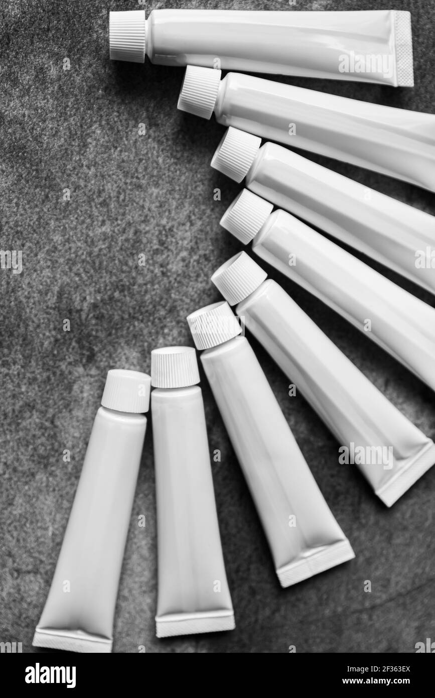 Container of white tubes on dark background with copy space, concept ...