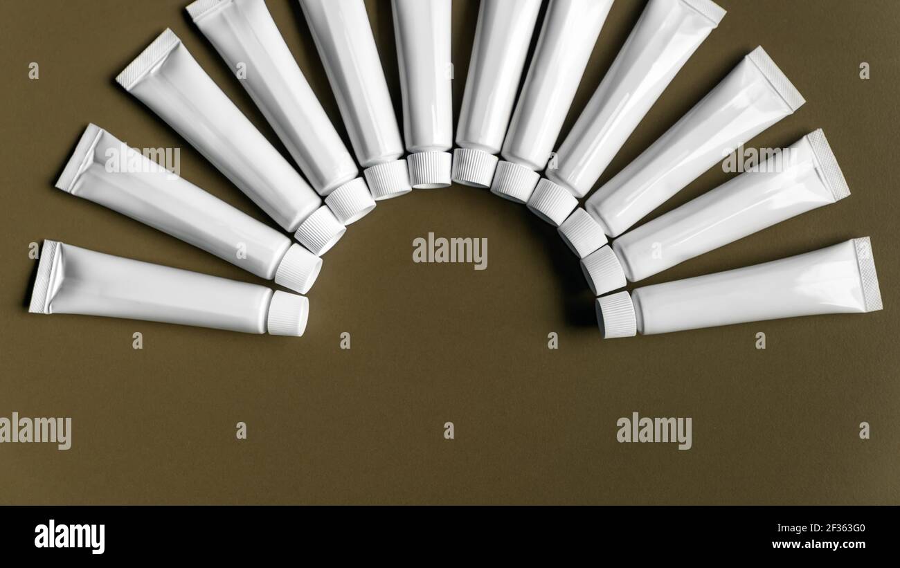 Container of white tubes on dark background placed in a semi-circle and ...